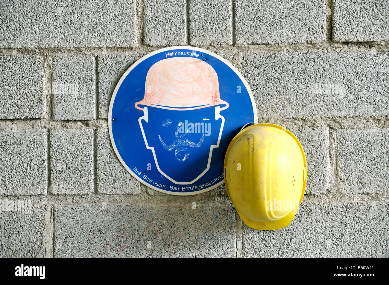 Construction helmet hanging on a wall next to a hard hat area safety ...