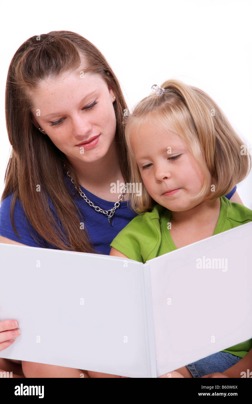 A teenager and child are reading a book together Stock Photo - Alamy
