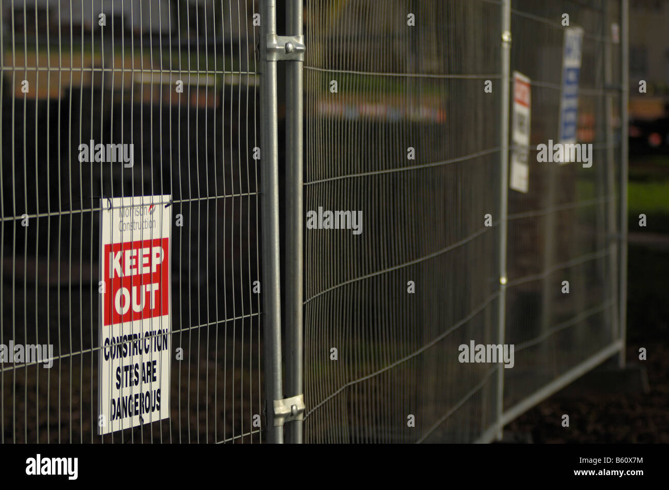 Fencing around building site with safety notice Stock Photo - Alamy