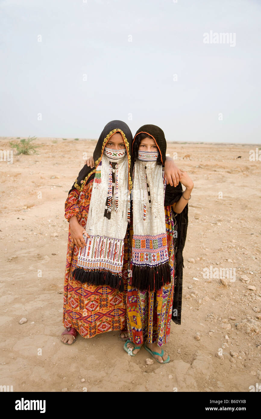 Two young Rashaida girls, 10-15 years old, wearing their colourful traditional costume, desert ...
