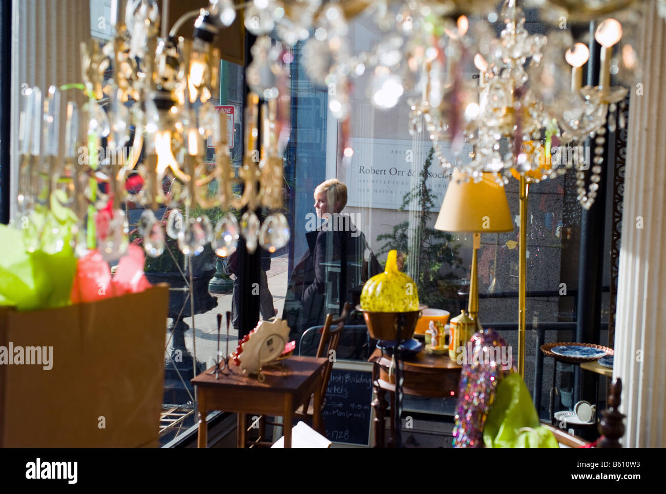 A woman walks past an antiques shop window in New Haven Connecticut USA ...