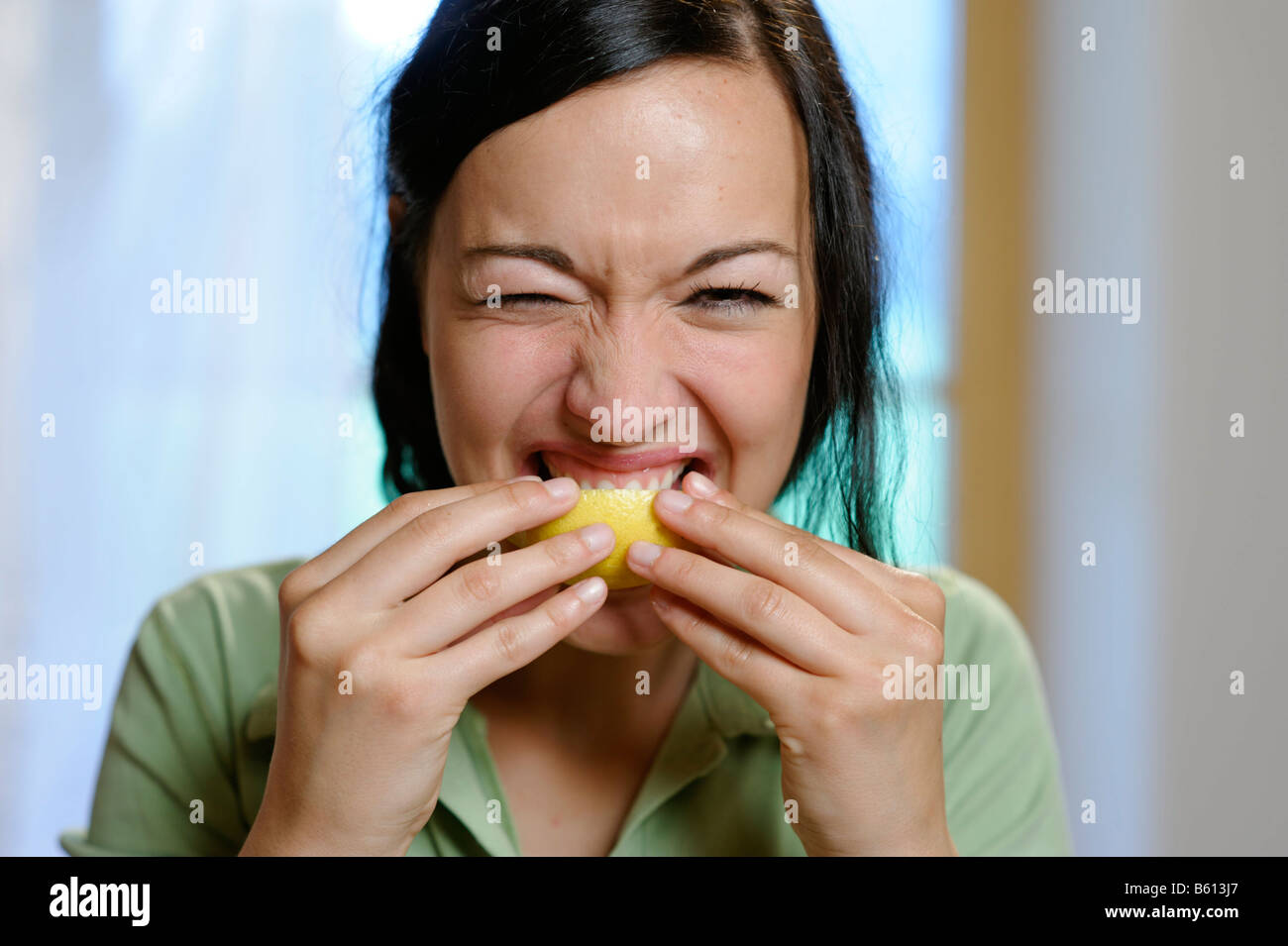 Young women sucking a lemon, vitamin C Stock Photo - Alamy