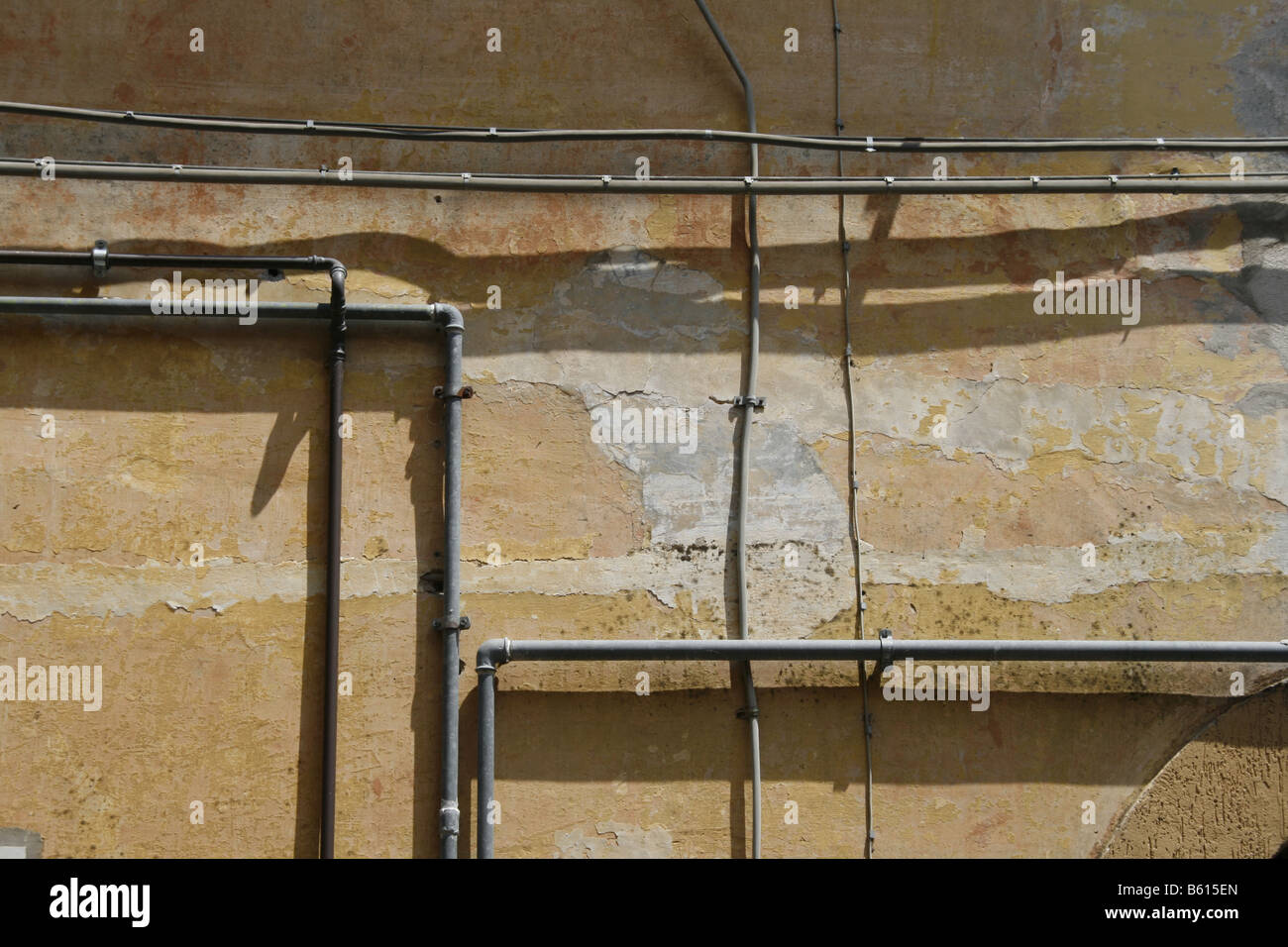 electricity power wiring circuit pipes tubes on side of property wall ...