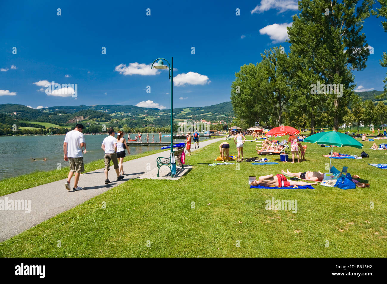 Sunbathers lying on the lawn next to Lake Stubenbergsee, Stubenberg am ...