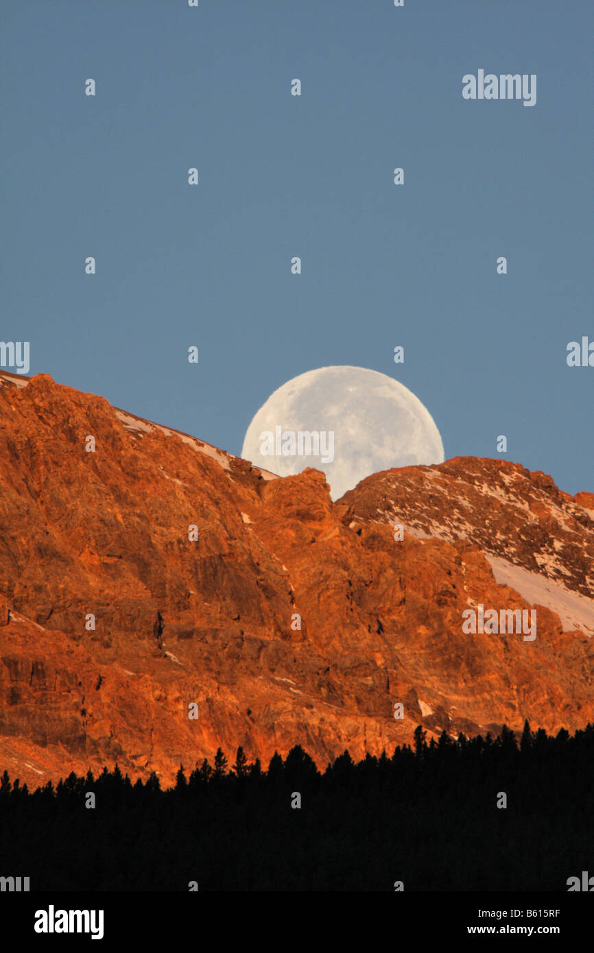 Full moon behind mountain in scenic Alberta Stock Photo - Alamy