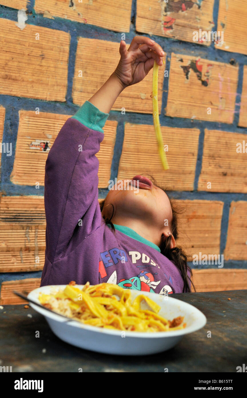 Girl eating ribbon noodles with her fingers, Slum Area Plan 3000, Santa ...