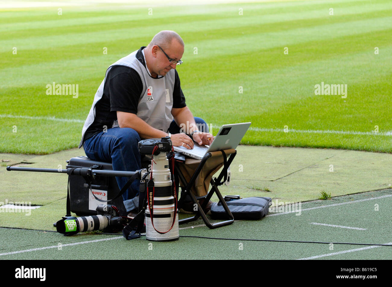 Press photographer in the stadium at the edge of the playing field ...