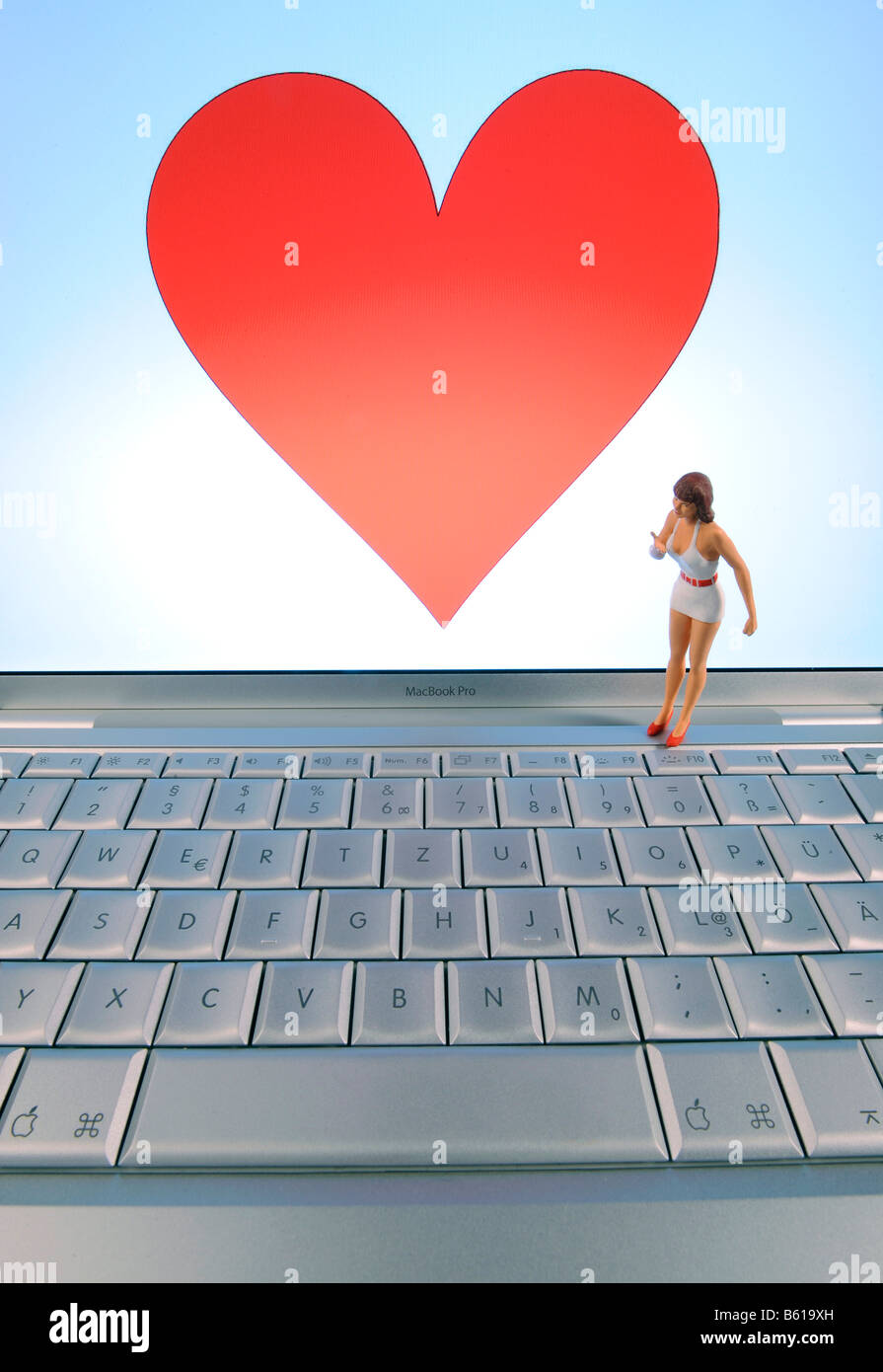 Woman's figure on a keyboard, heart on the monitor, symbolic picture ...