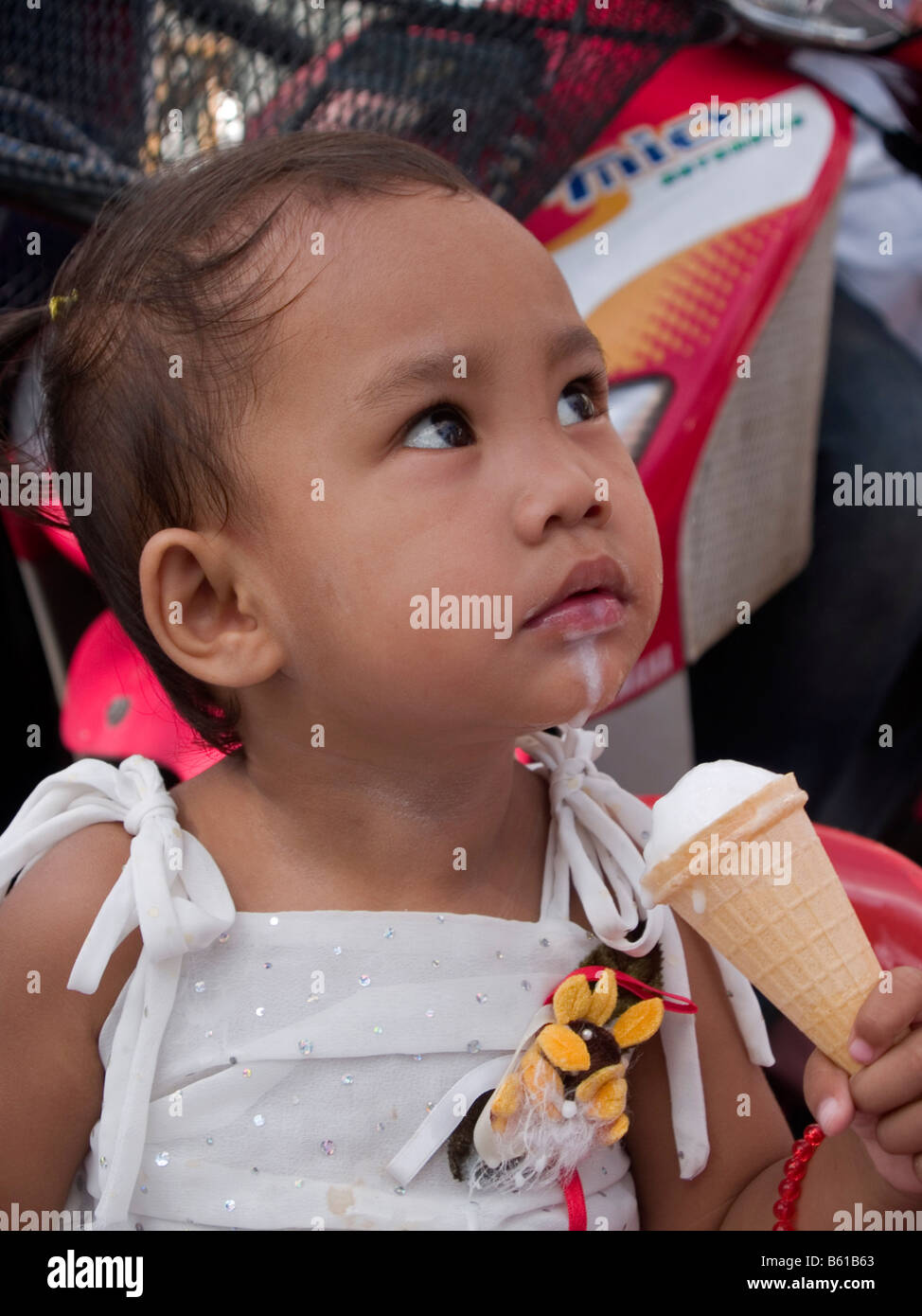 little girl with an ice cream cone at the Phuket Vegetarian Festival in ...