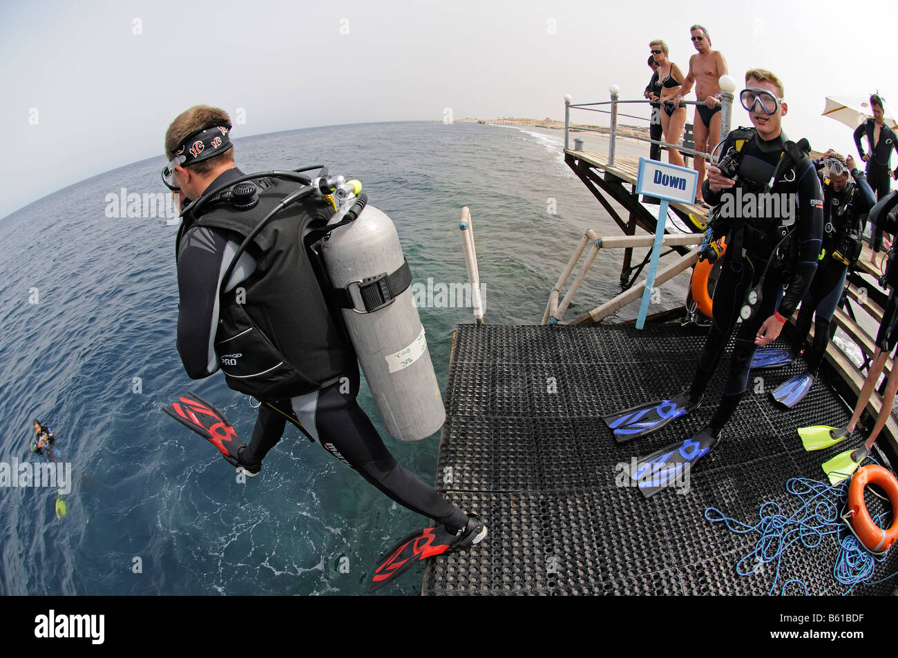 scuba diver jumping into water from jetty Stock Photo - Alamy