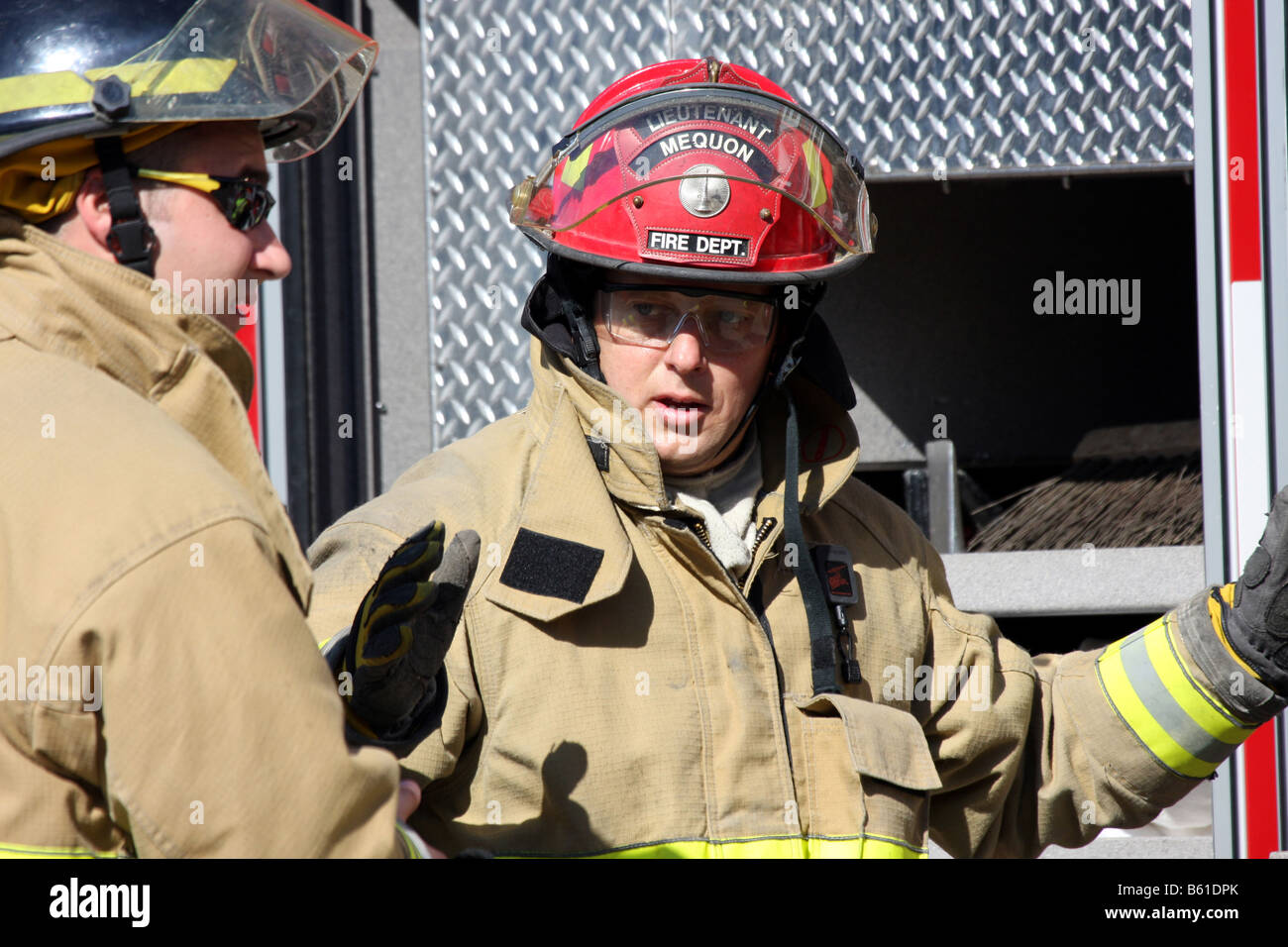 A Mequon Fire Department Lieutenant and fireman are discussing how to ...