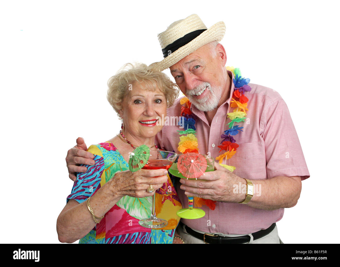 An attractive senior couple on vacation drinking tropical drinks with ...