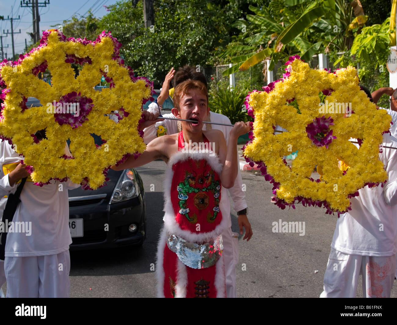 man in a trance with flowers at the bizarre Vegetarian Festival in ...