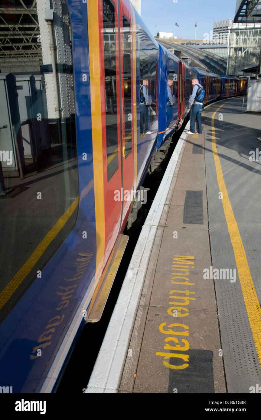 A man getting on a train at London Waterloo Railway Station, London, UK ...