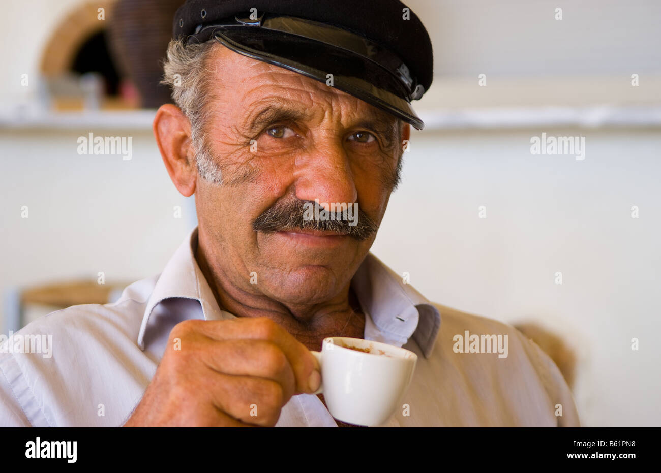 Local man portrait with Greek coffee with Greek hat at restuarant in ...
