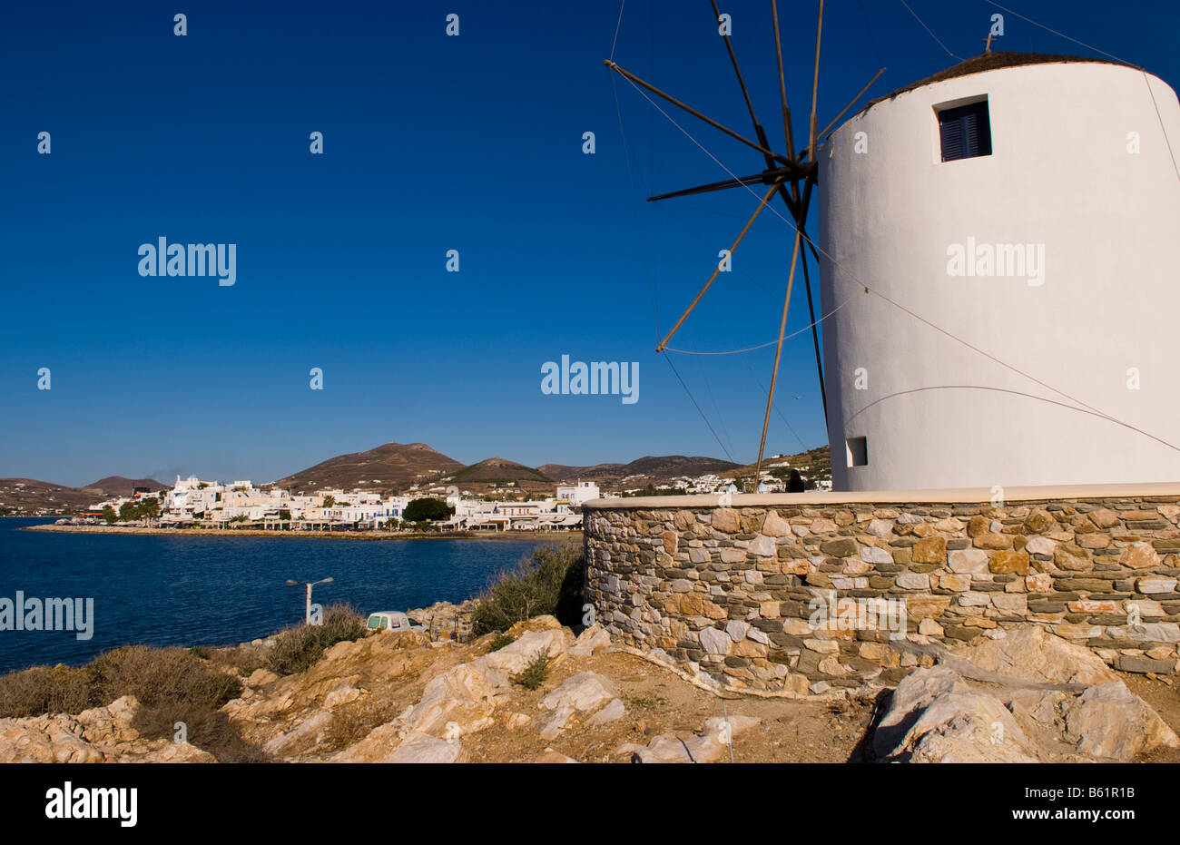 Famous windmill in harbor with center of city of Parikia capital city ...
