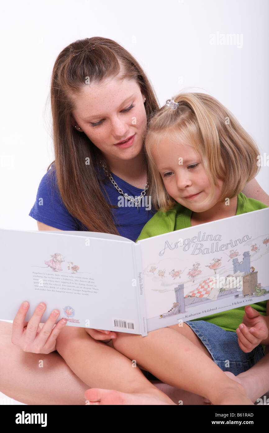 A teenager and child are reading a book together Stock Photo - Alamy