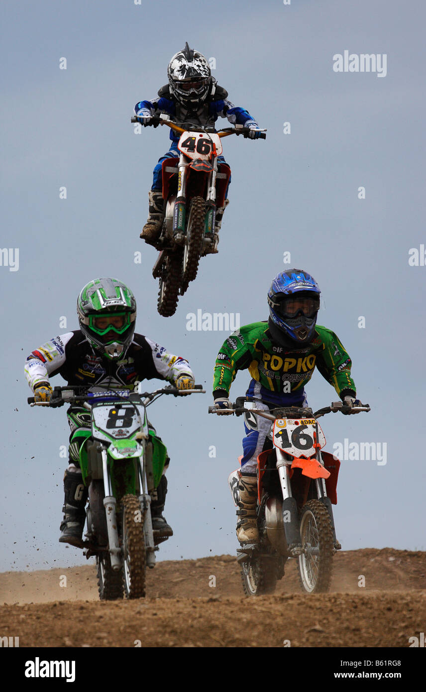 Three children riding motocross Stock Photo - Alamy