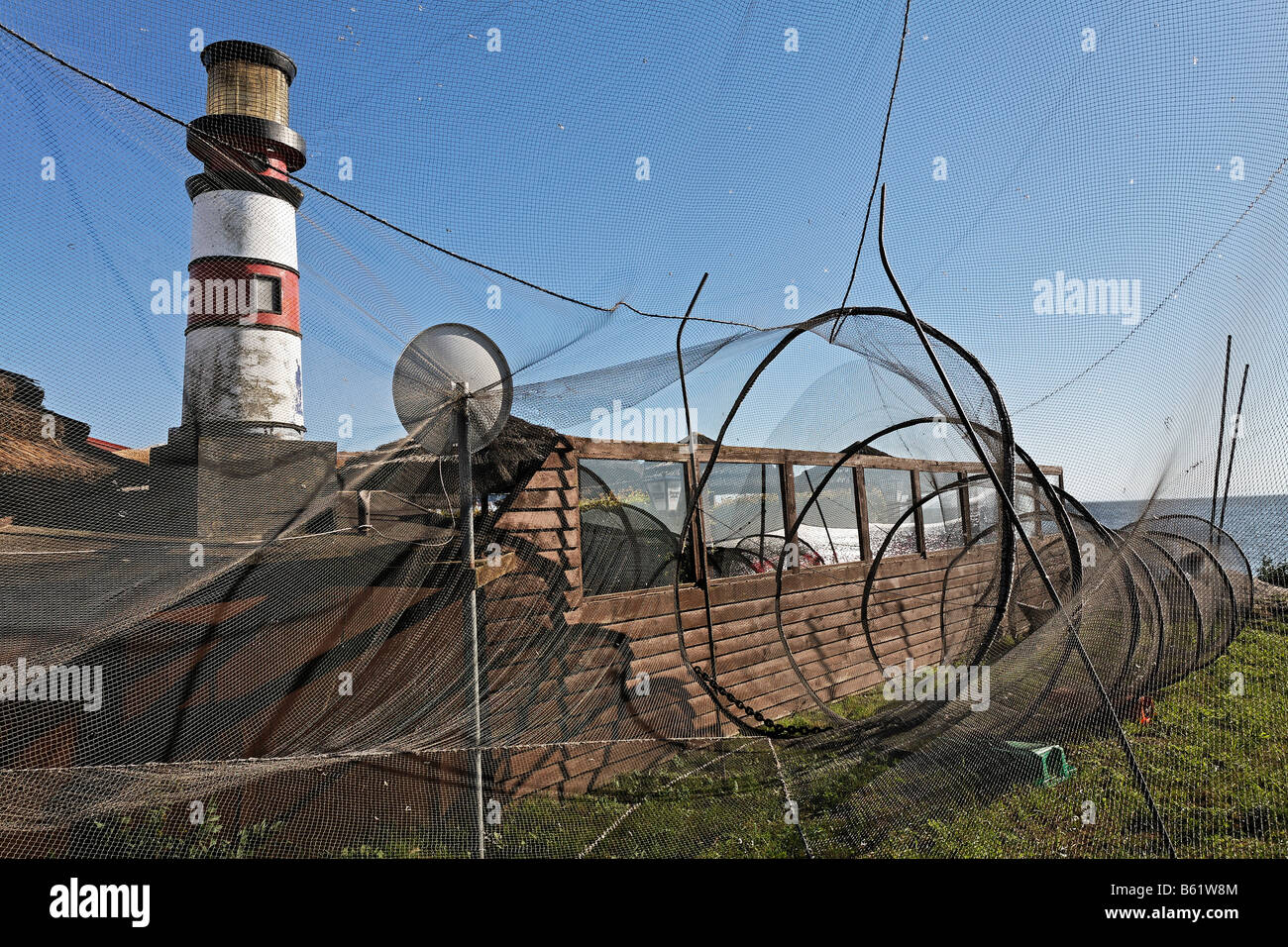 Fishing nets hanging out to dry, decorative lighthouse, Kaminke harbour ...