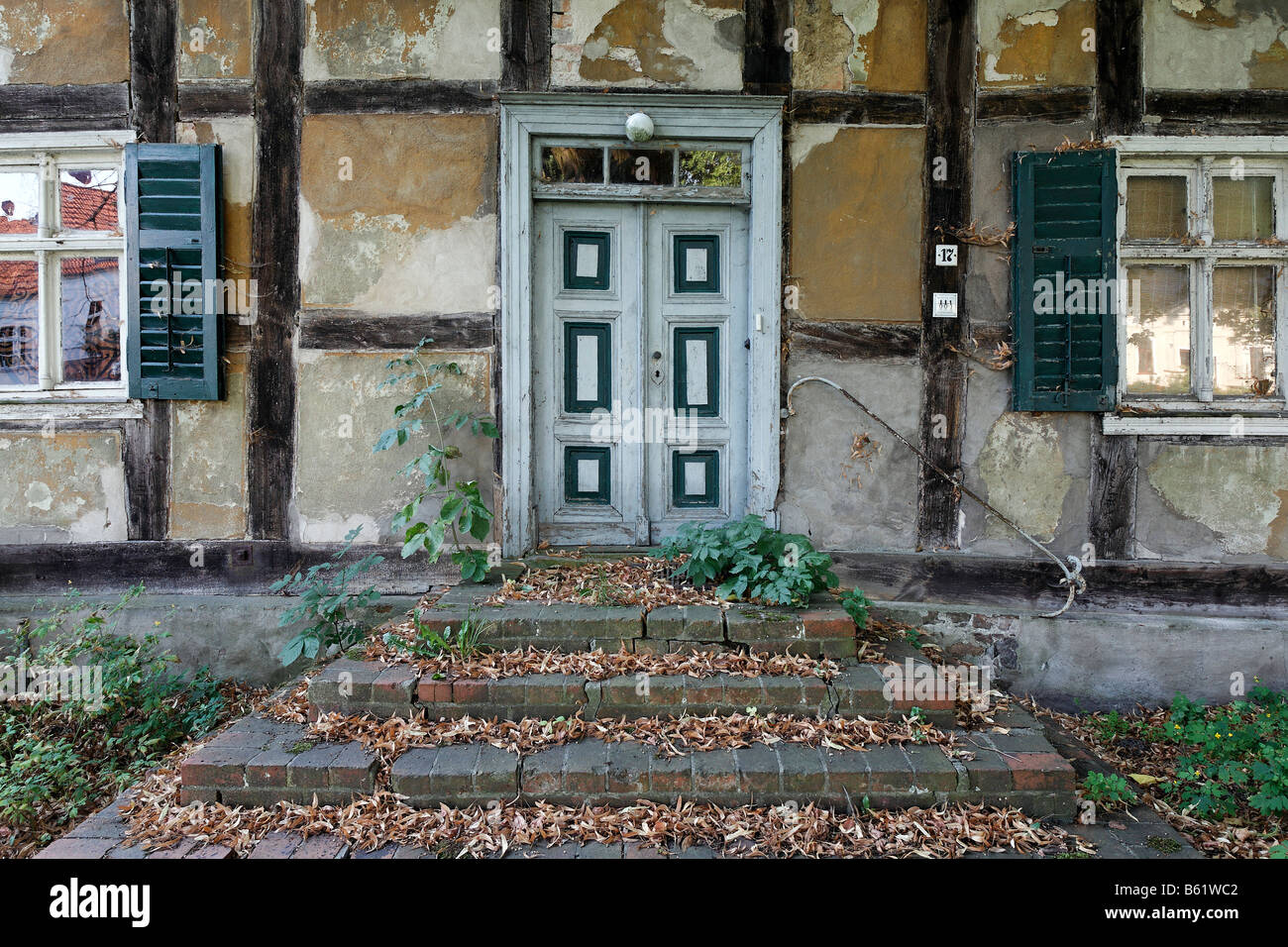 Facade of an old half-timbered farmhouse, steps and housedoor ...