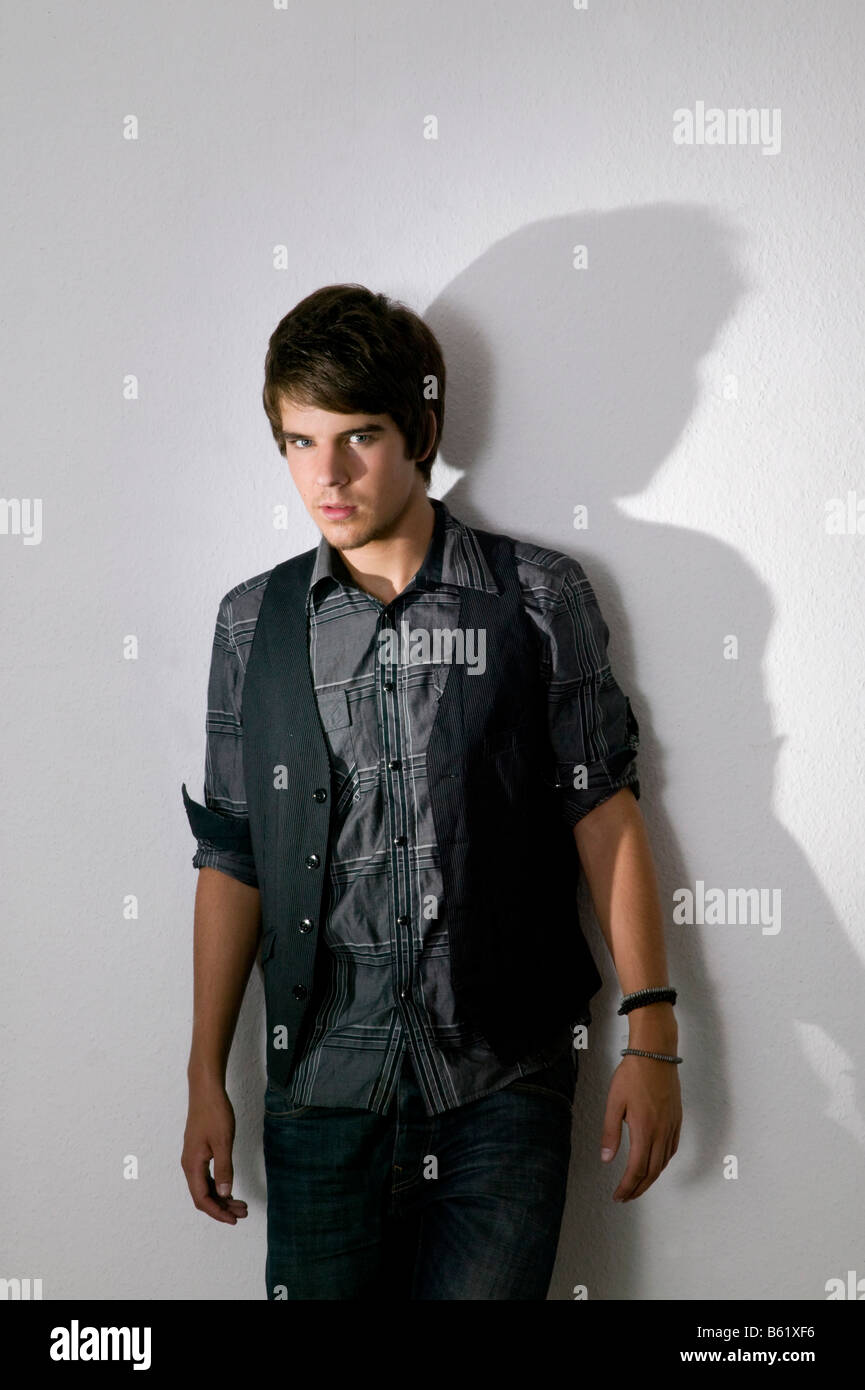 Young man standing confidently in front of a wall Stock Photo - Alamy