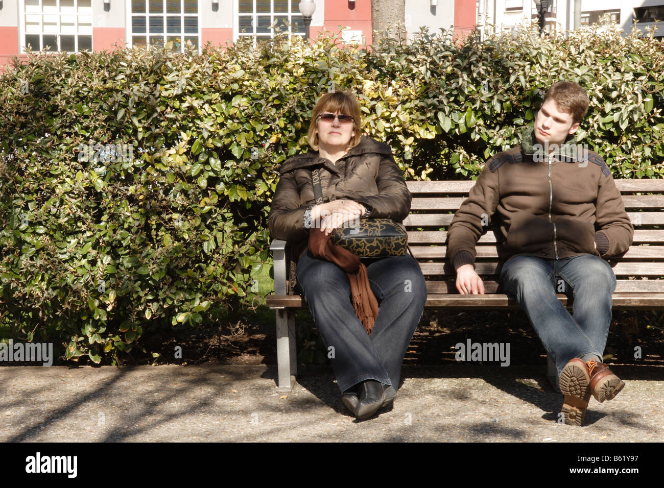 Two people sunning themselves on a park bench in Gijon Spain Stock ...