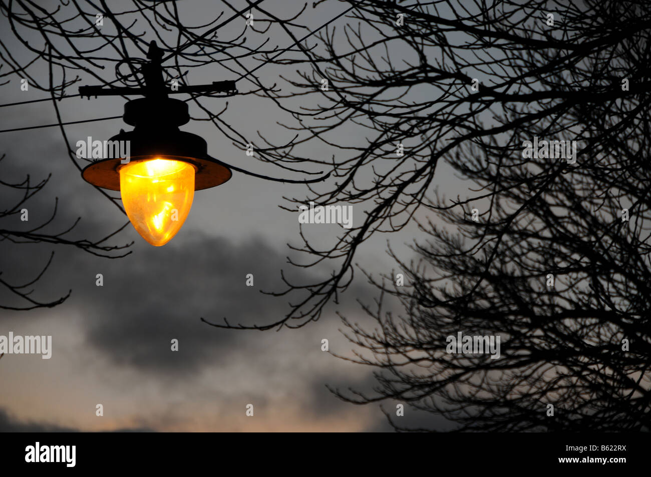A hanging street lamp at twilight Stock Photo - Alamy