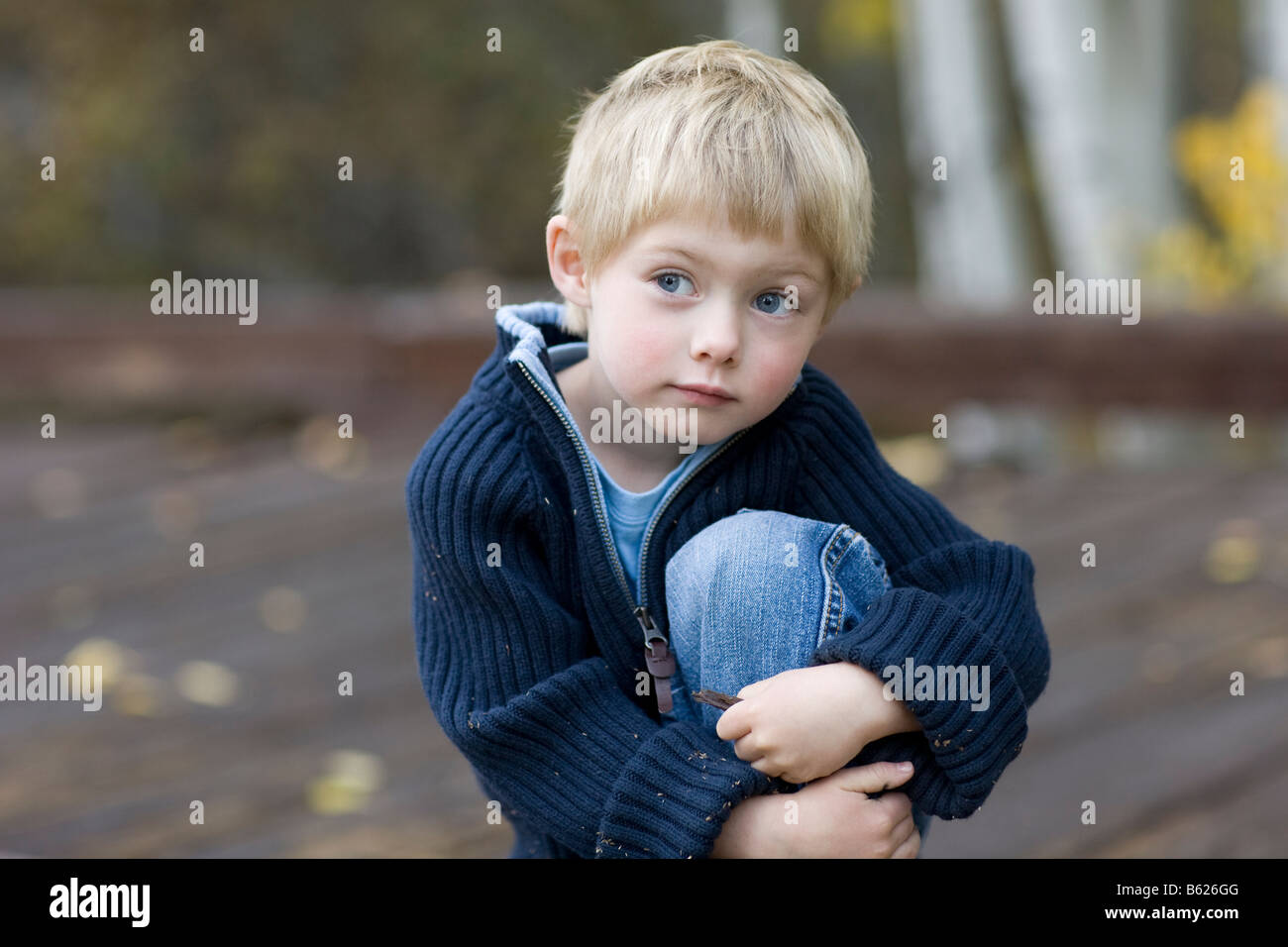little boy crouched down on bridge Stock Photo - Alamy