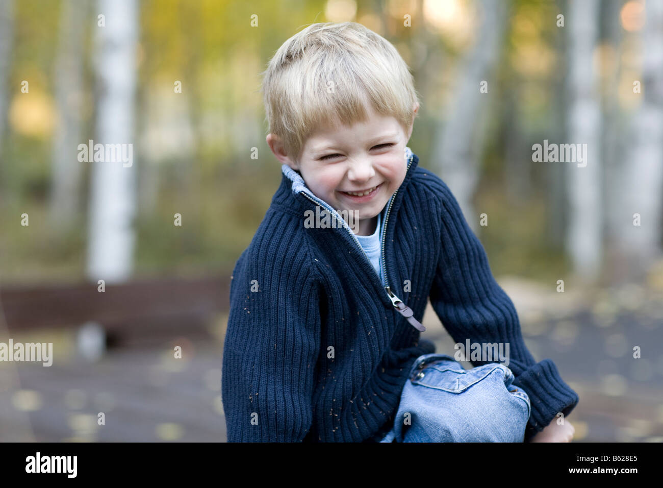 little boy crouched down, giggling Stock Photo - Alamy