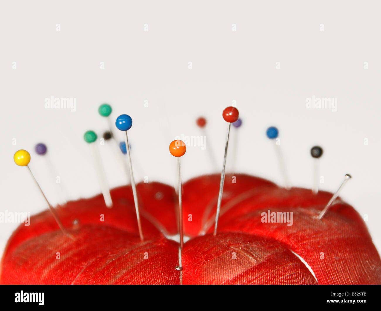 A close up of colourful pins in a pin cushion Stock Photo - Alamy