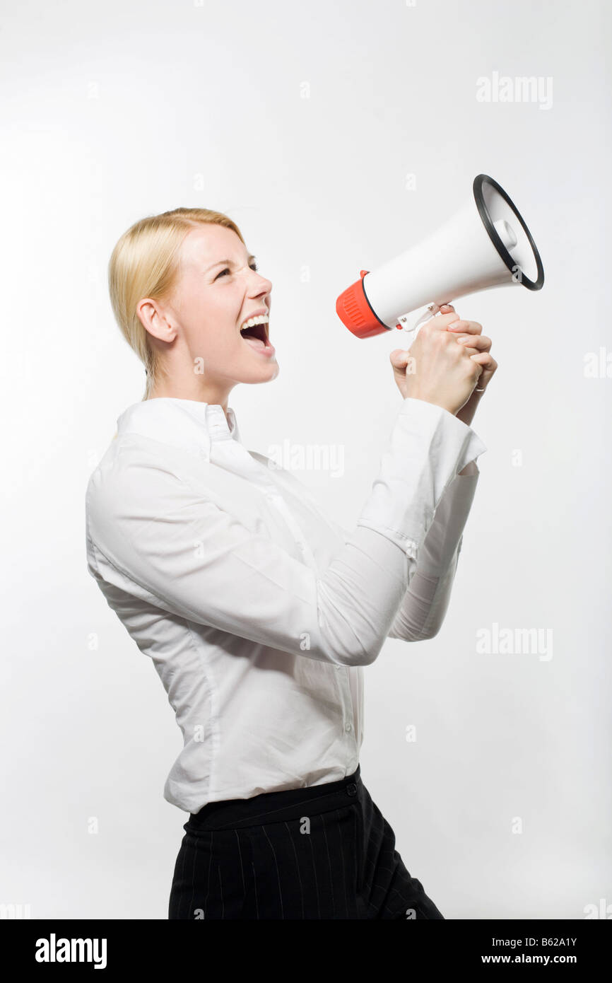 Young blonde woman shouting into a megaphone Stock Photo - Alamy