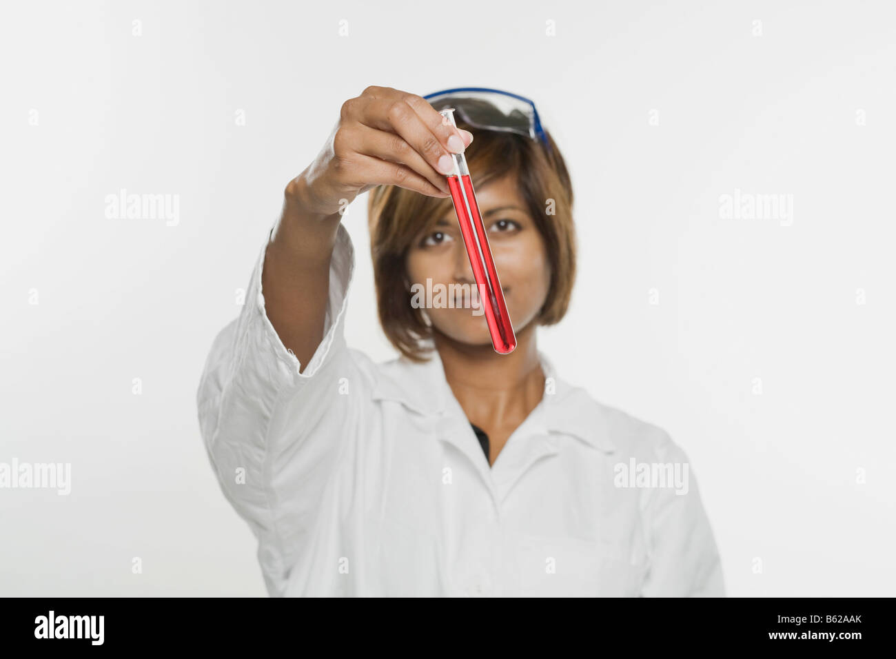 Laboratory worker holding up a red test tube Stock Photo - Alamy
