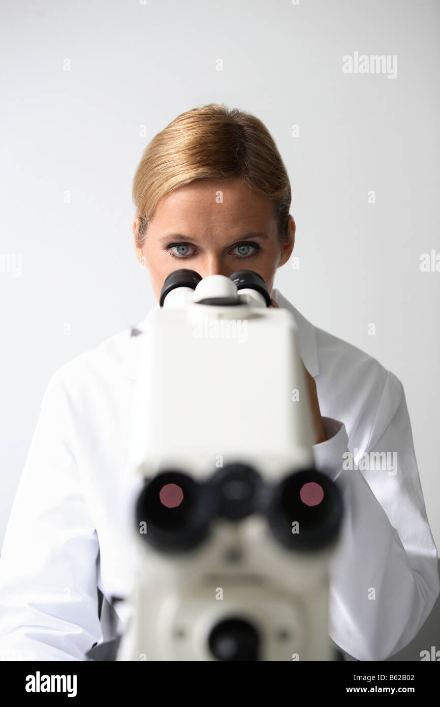 Researcher looking through a microscope hi-res stock photography and ...