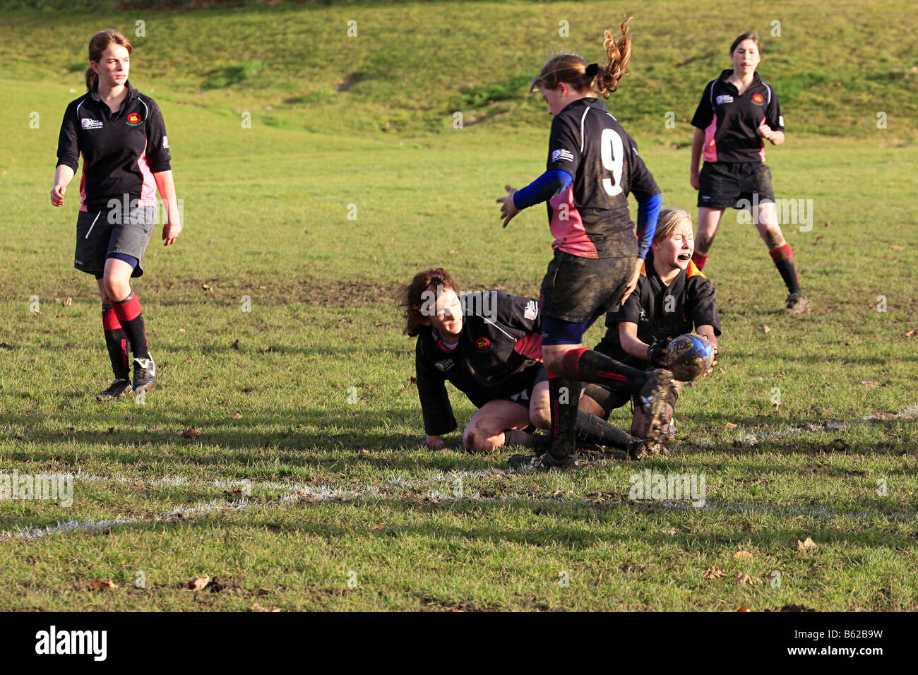 Teenage girls playing Rugby on a cold wet autumn afternoon Stock Photo ...