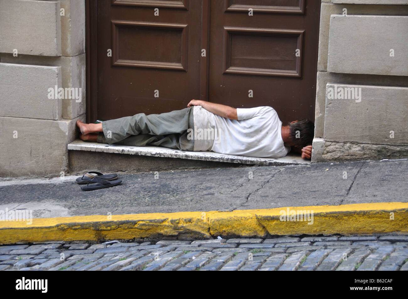 a homeless man sleeps in the doorway of a historic building in old san ...