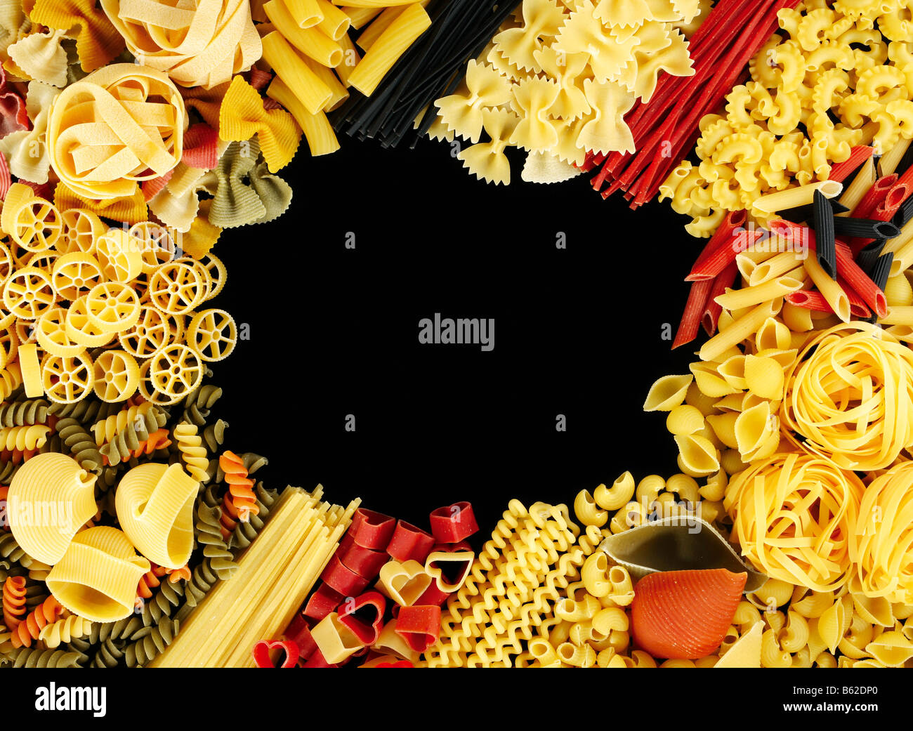 Raw color pasta mix with black background Stock Photo - Alamy