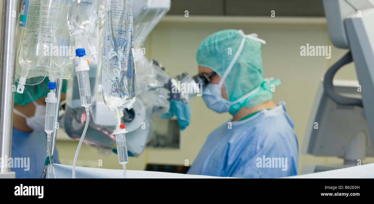 Neurosurgeon using microscope during surgical procedure to remove a ...