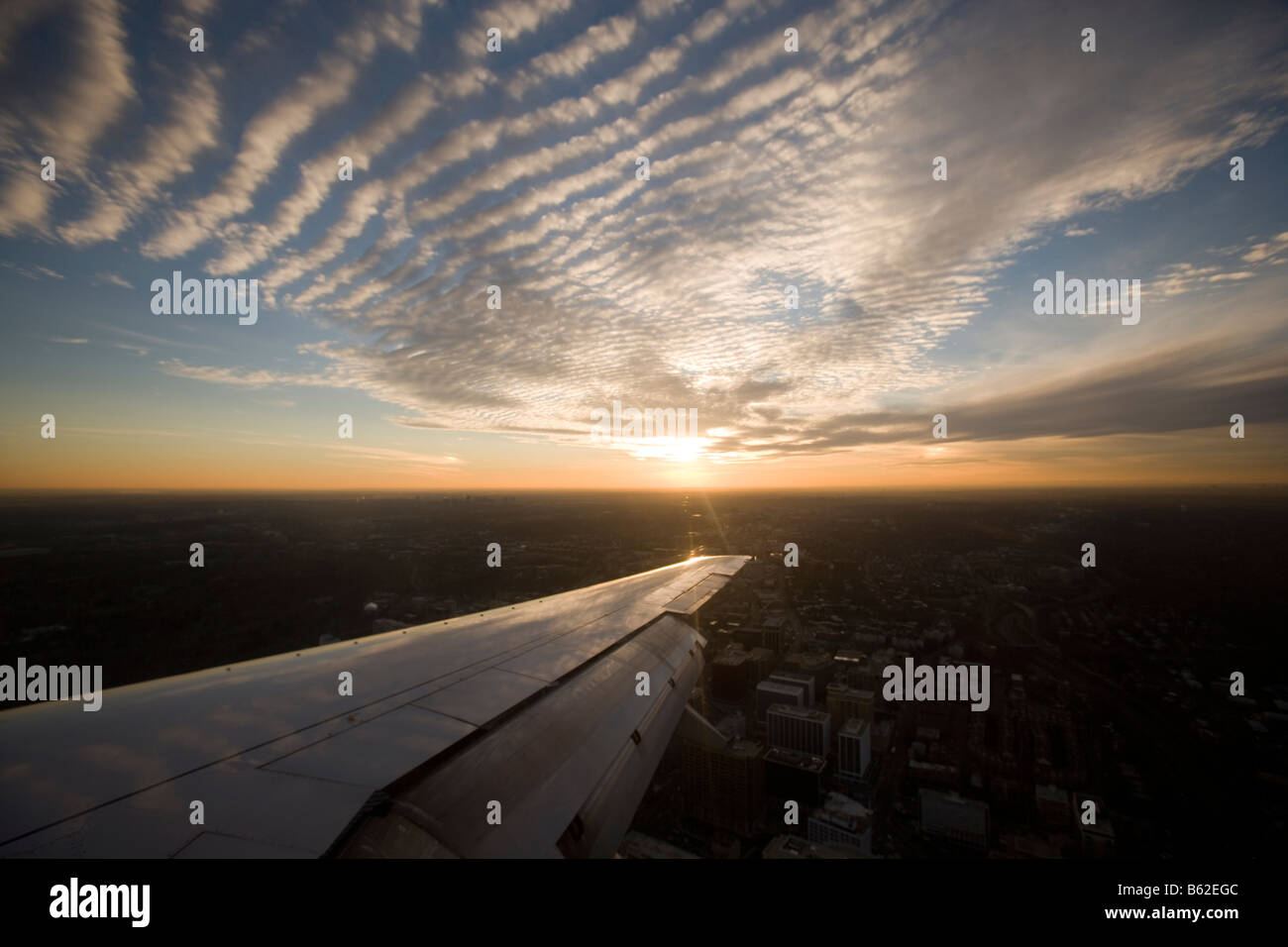 USA Washington DC Setting sun lights wing of passenger jet approaching ...