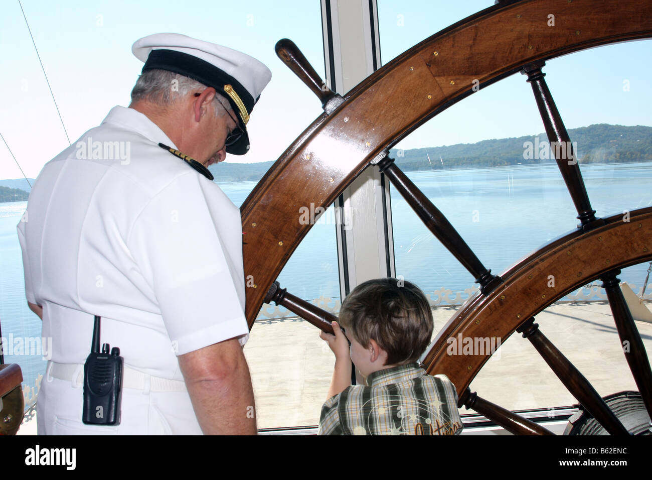 The Captain helping a little boy steering the wheel in the steering ...