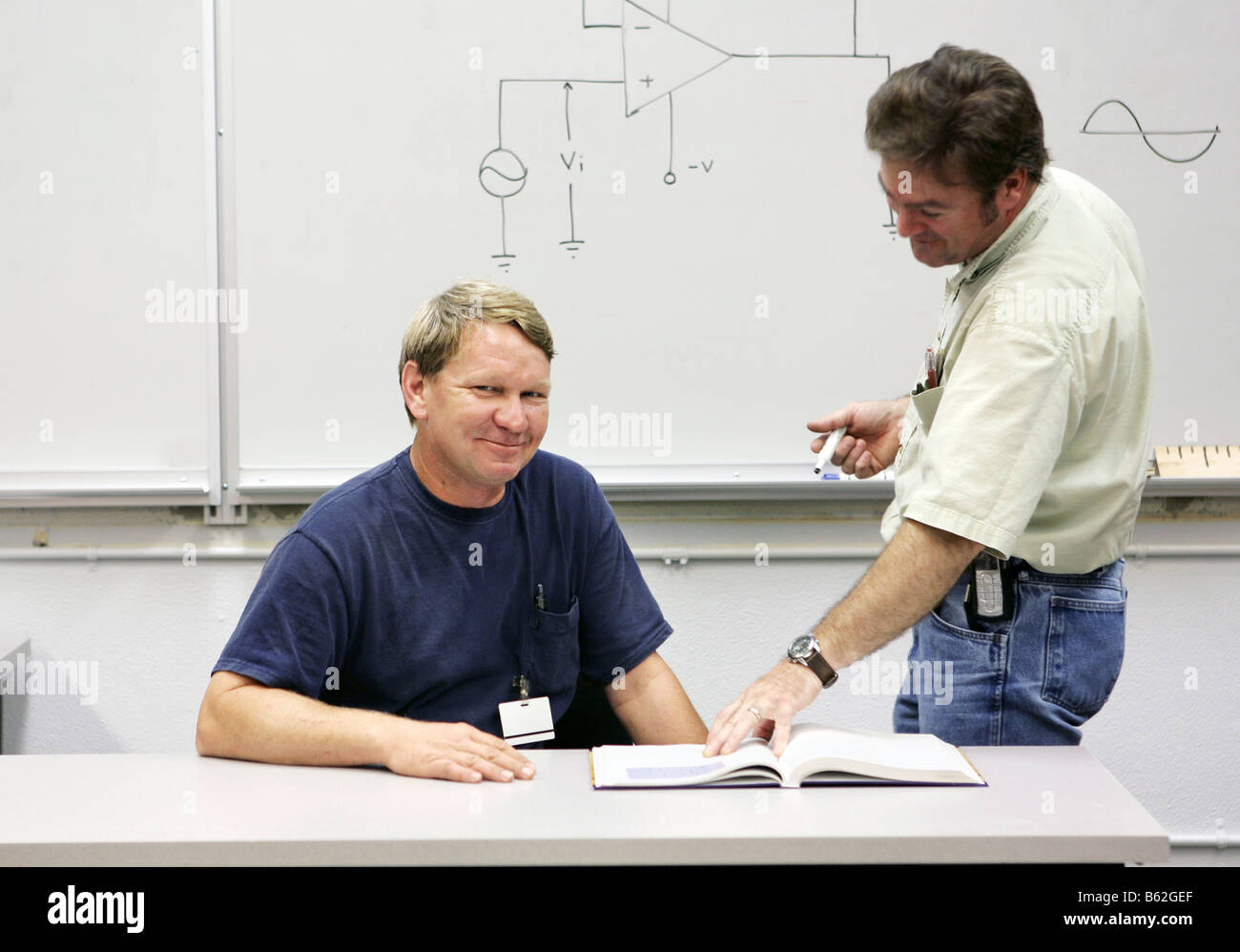 A middle aged adult education student with his teacher smiling into the ...