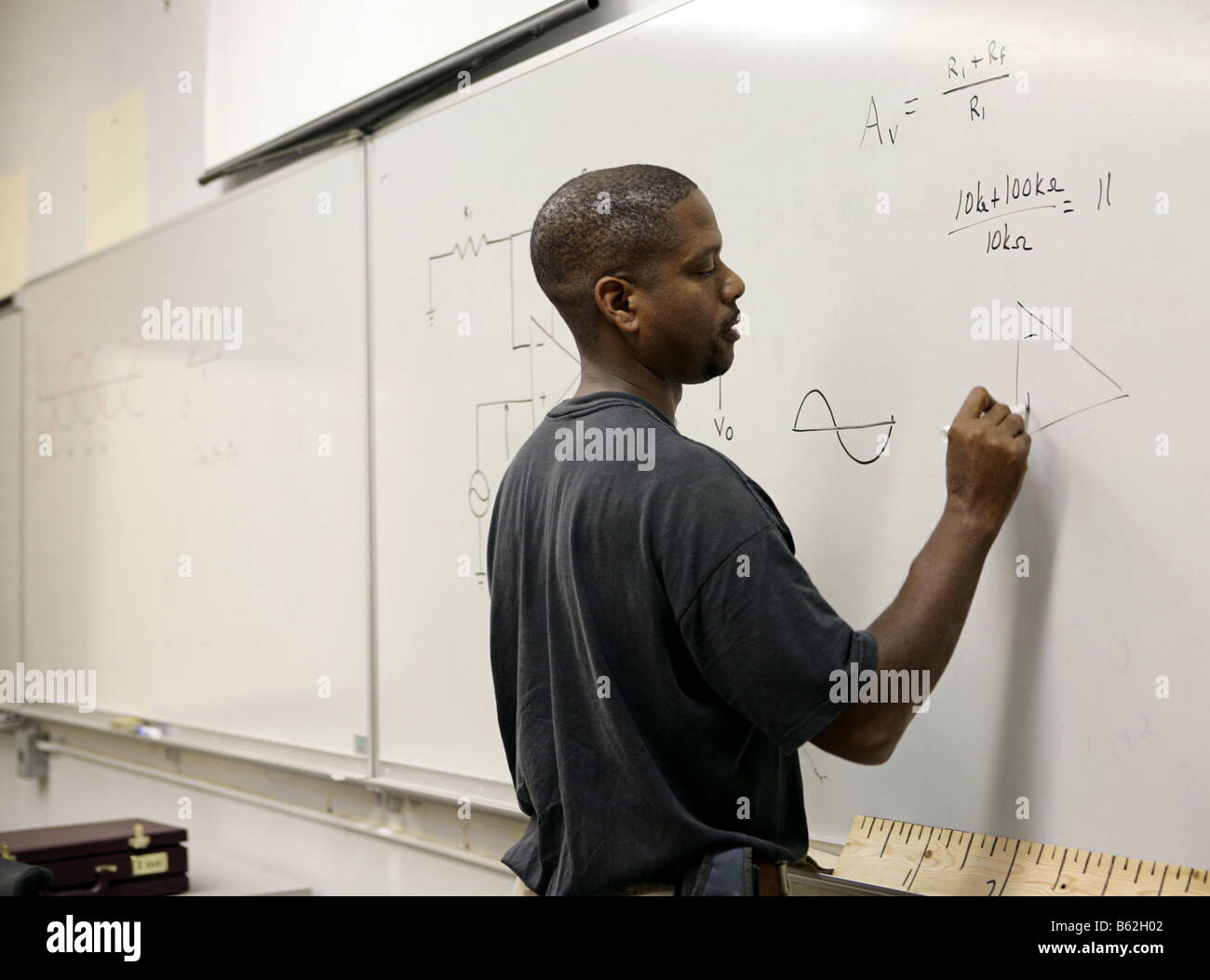 A handsome african american student doing trigonometry at the board ...