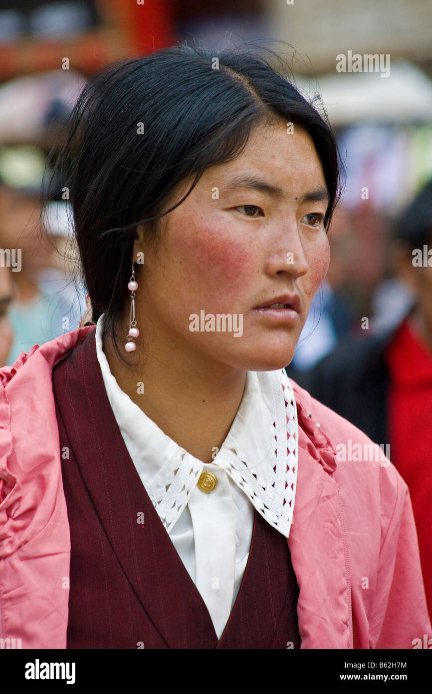 Beautiful young Tibetan woman pilgrim wearing earrings in the Barkhor ...