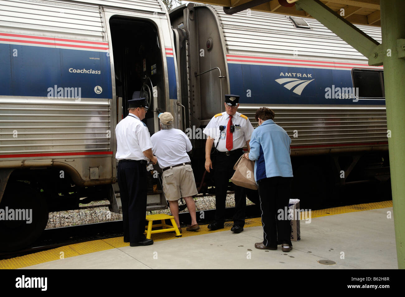 Amtrak railroad conductors assisting passengers onto train DeLand Train ...