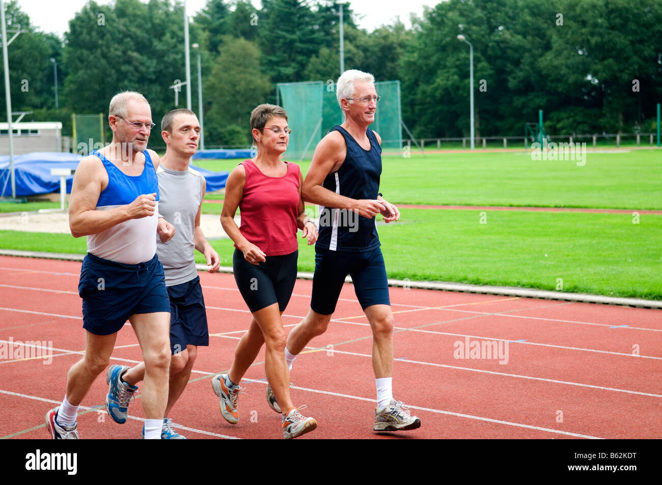 Group of running people on a race track Stock Photo - Alamy