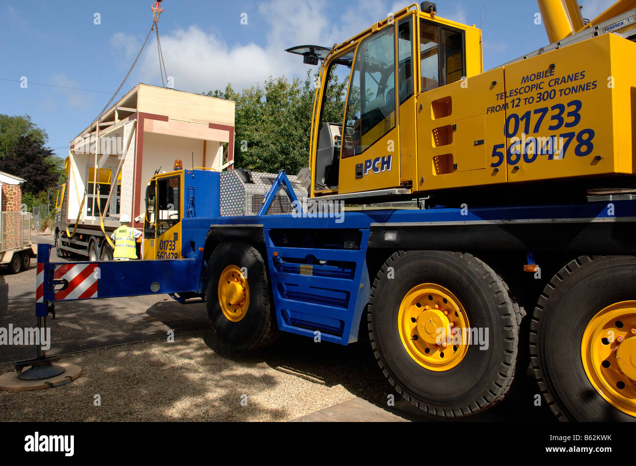 Lifting modular building section off back of a lorry by crane Stock ...