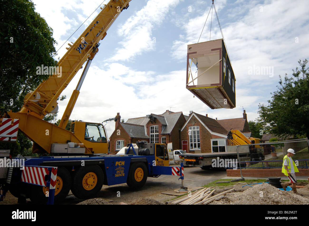 Lifting modular building section off back of a lorry by crane Stock ...