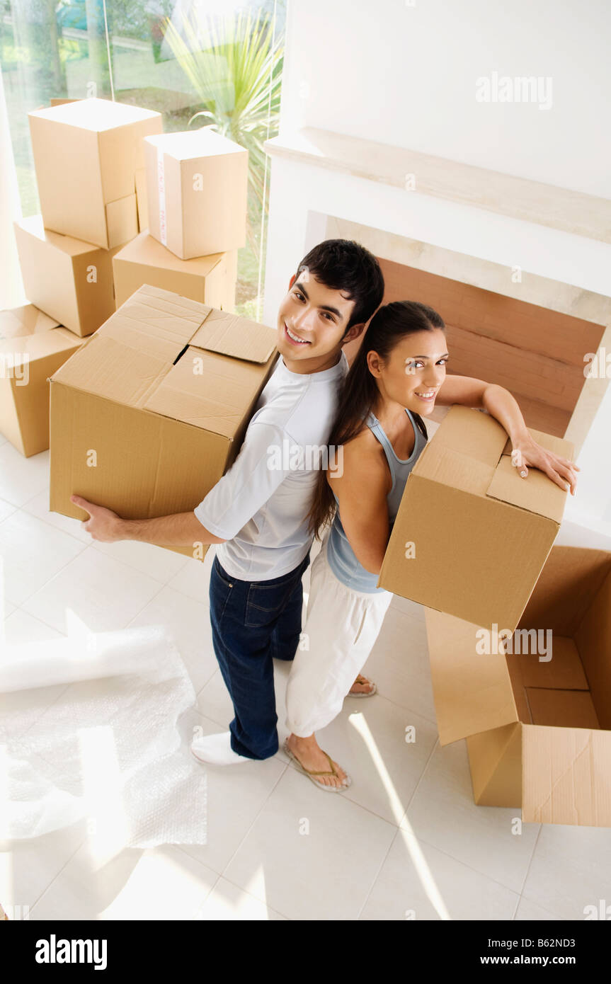 Portrait of a young couple holding cardboard boxes and smiling Stock ...