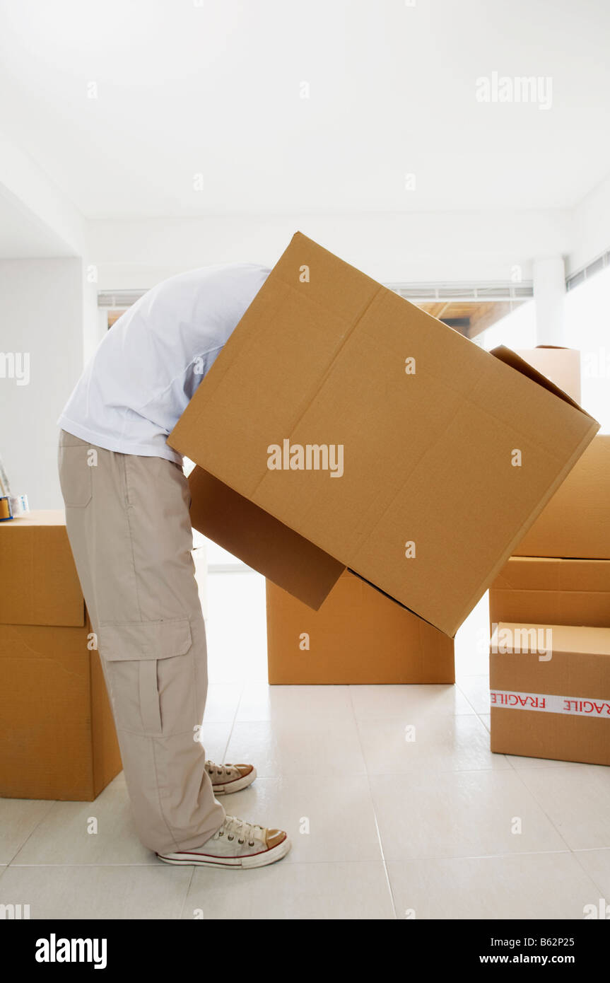 Person bending forward and holding a cardboard box Stock Photo - Alamy
