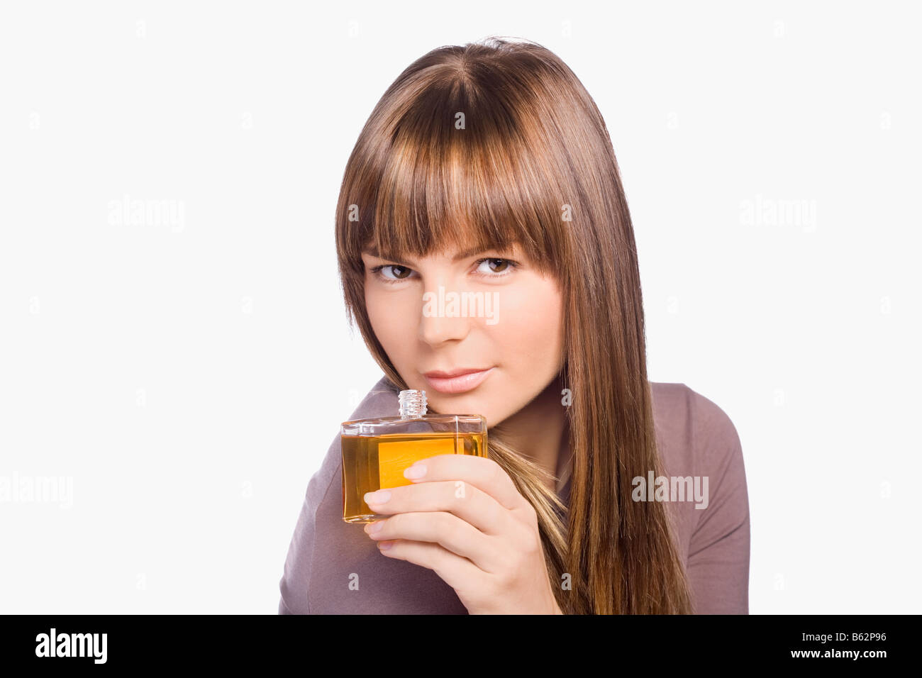 Portrait of a young woman smelling perfume Stock Photo - Alamy