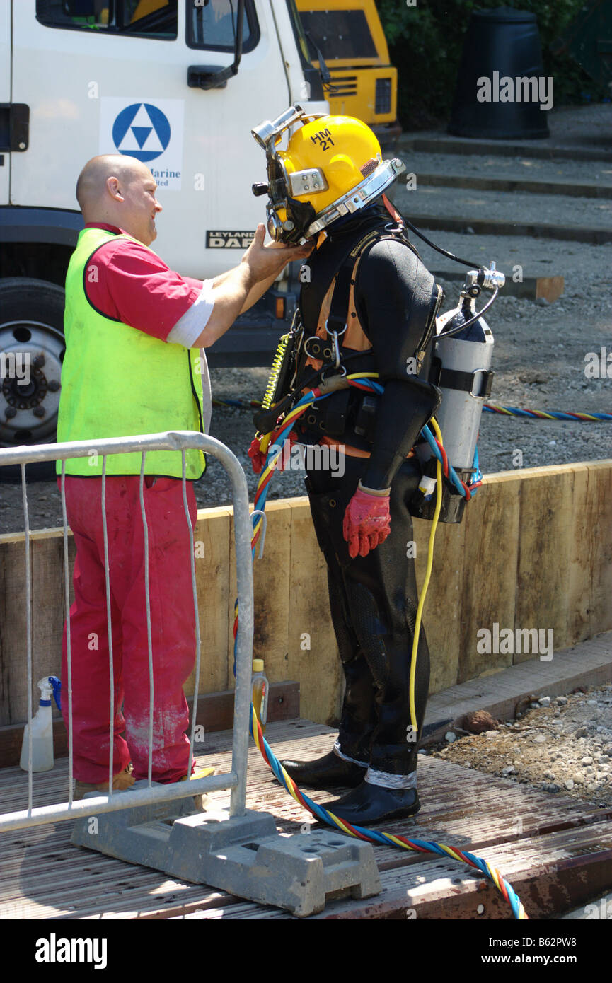 marine welder diver aided helped dressing helping Stock Photo - Alamy